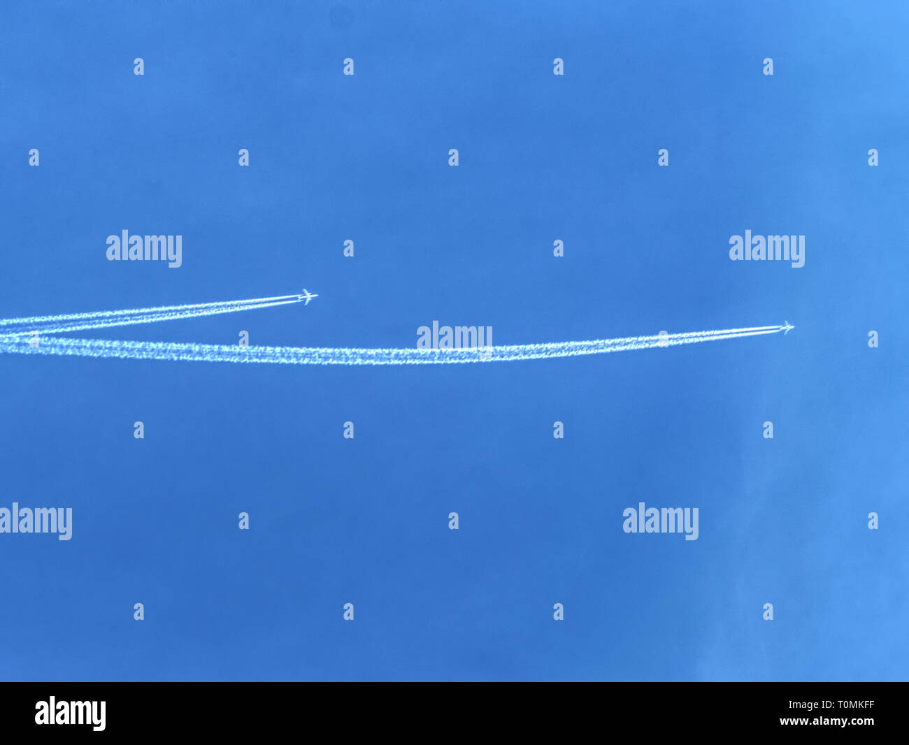 Crossing of airline lines on the blue sky above planet Earth Stock ...