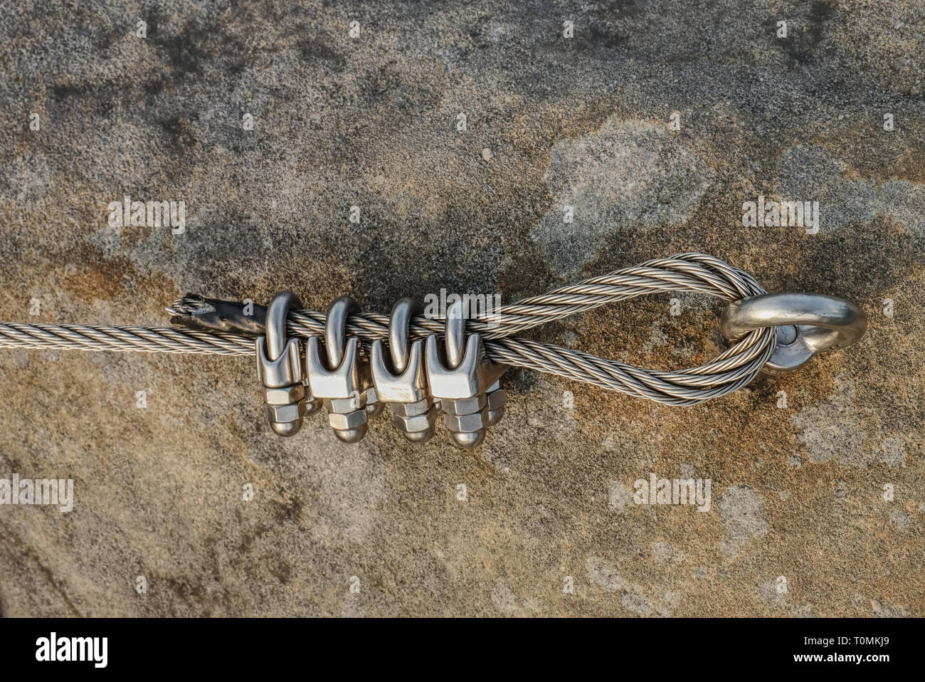 Srew with steel rope anchored into rocky wall. Difficult way on a ...