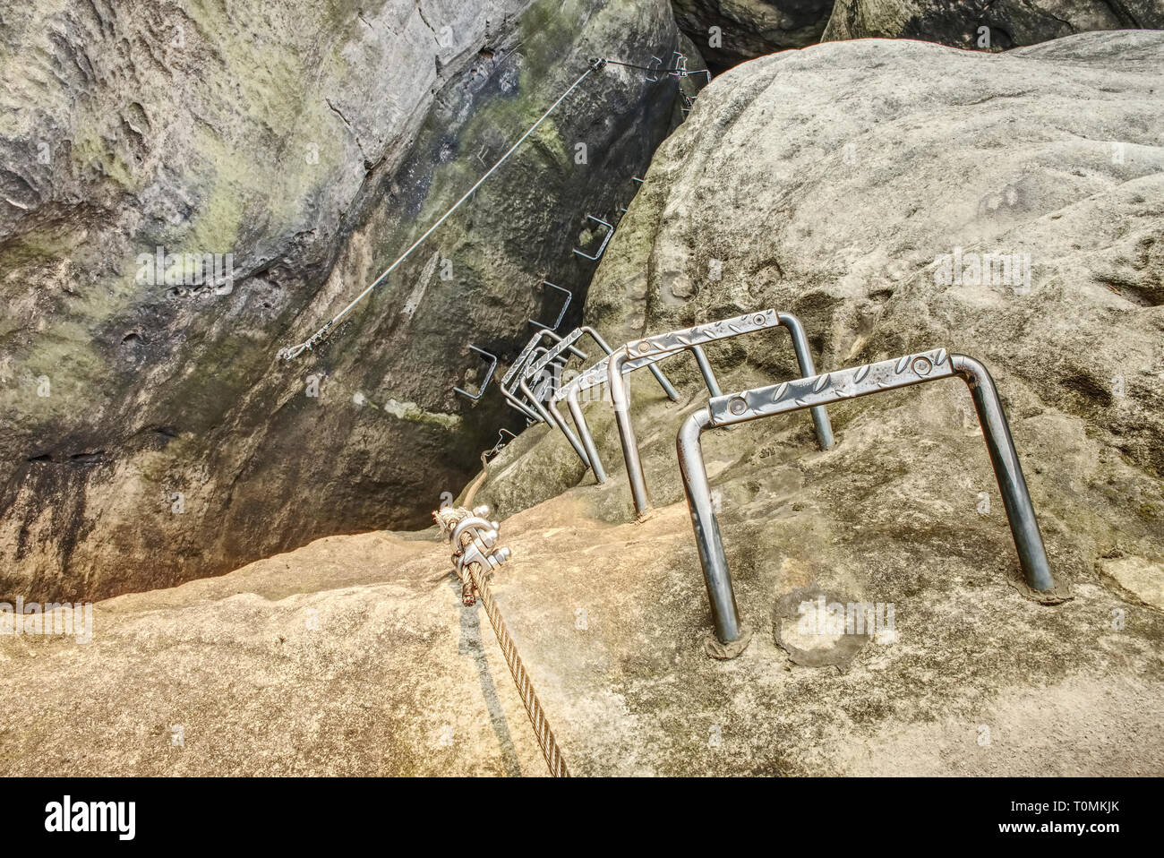 Climbing carabiner on a steel rope near steel steps on via ferrata ...