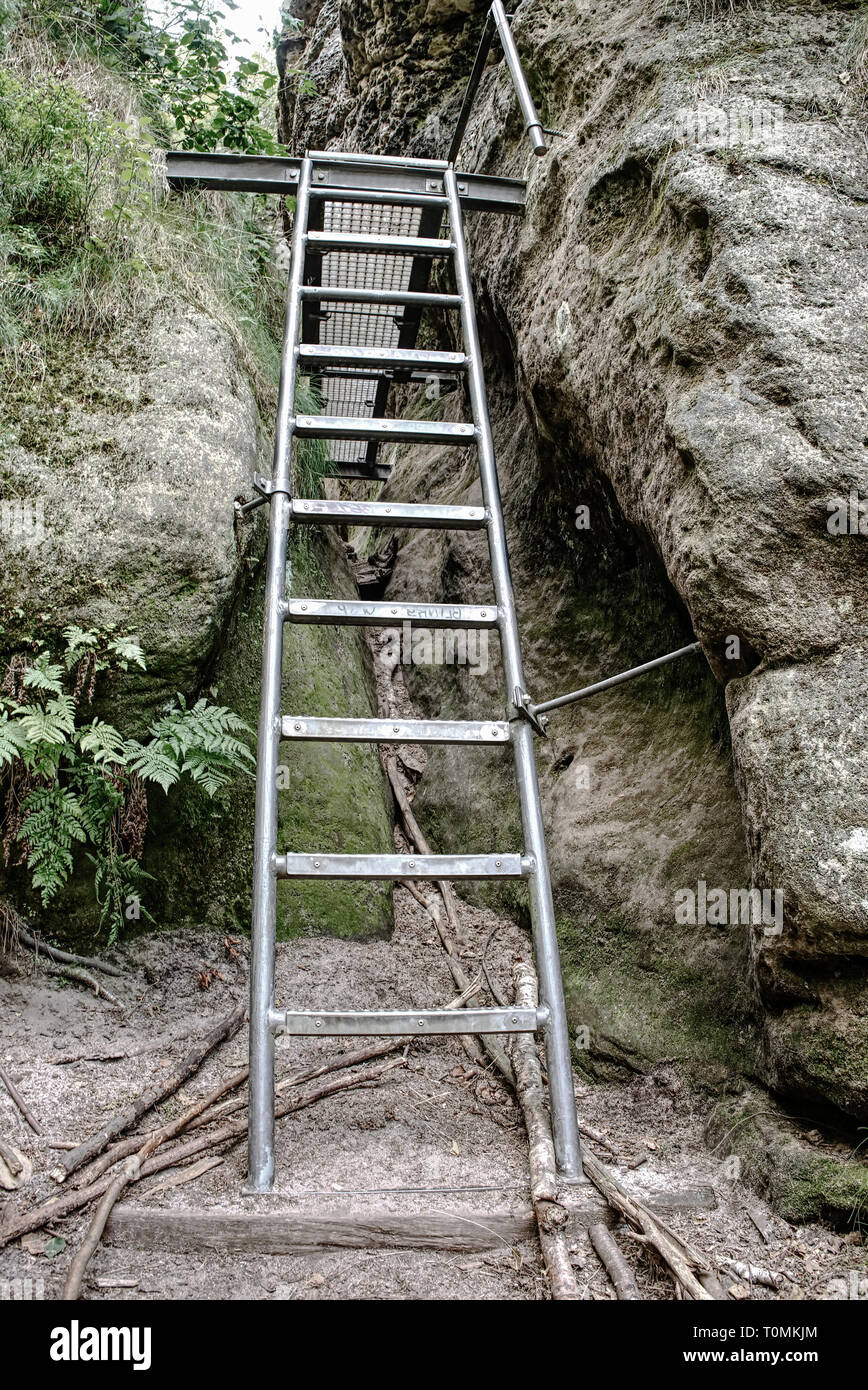 Metal ladder in mountains via ferrata. The steel cable with steel bolt ...