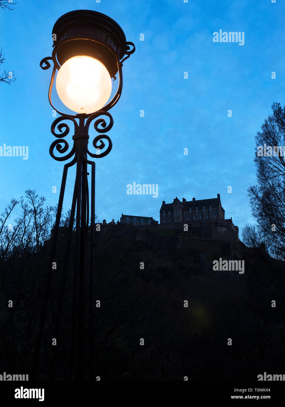 Street lamp coming on at Princes Street Gardens with Edinburgh Castle ...