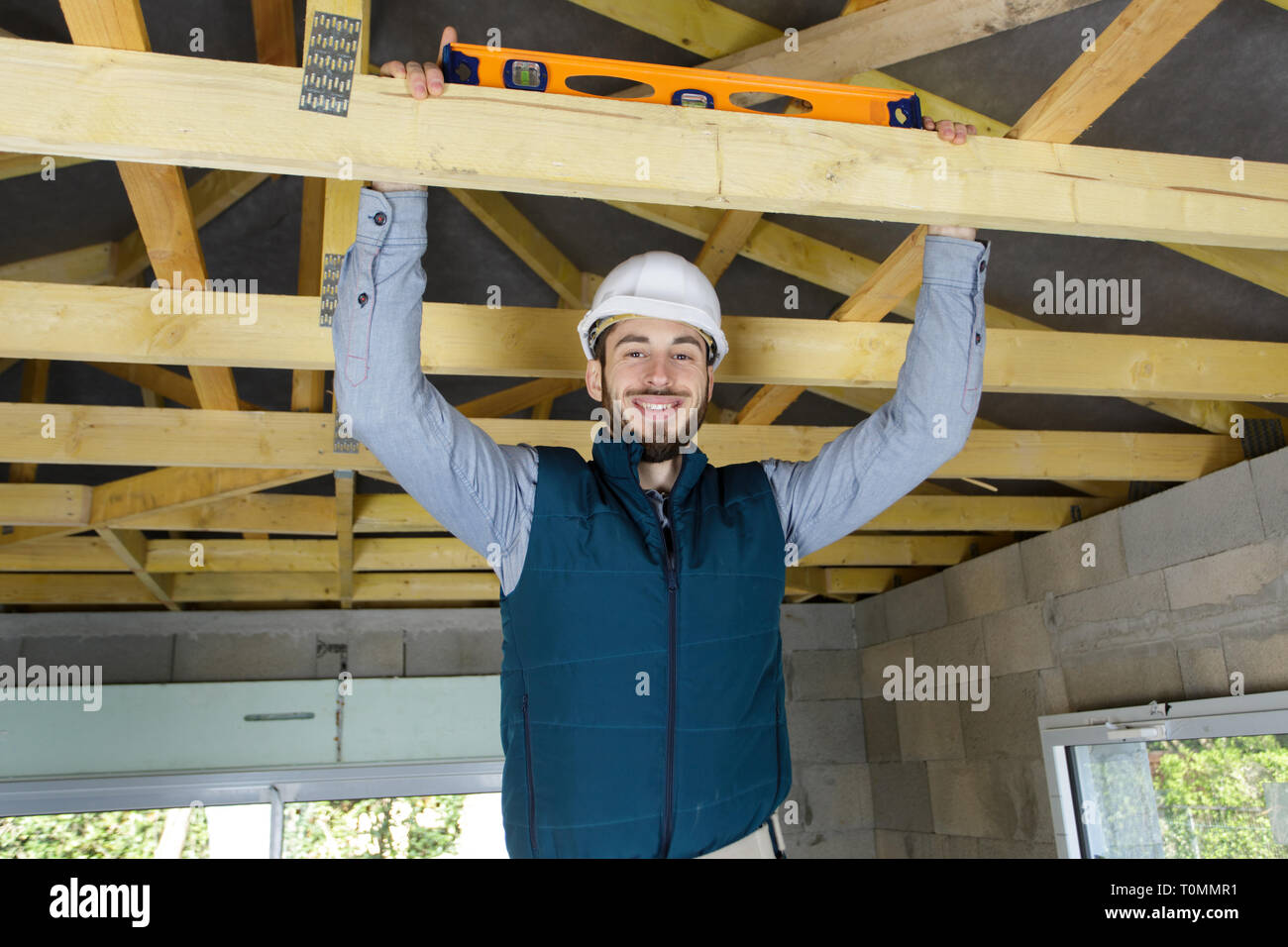 happy male construction worker adjusting ceiling Stock Photo - Alamy