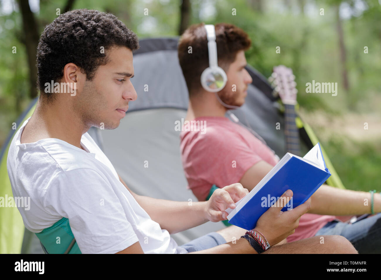 young men relaxing during camping Stock Photo - Alamy