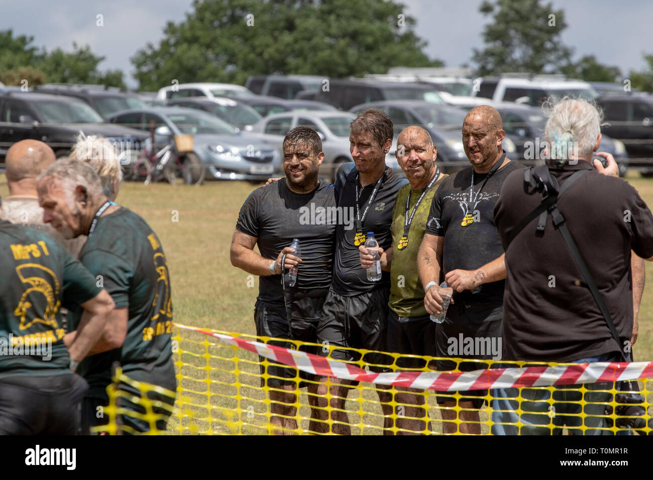 Group of four muddy men at the end of a mud run Stock Photo - Alamy