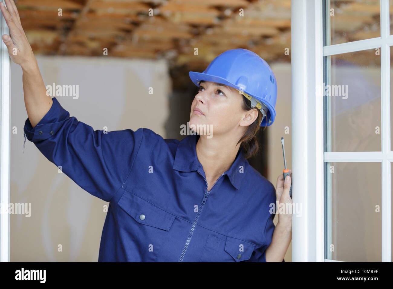 female window fitter checking installation Stock Photo - Alamy