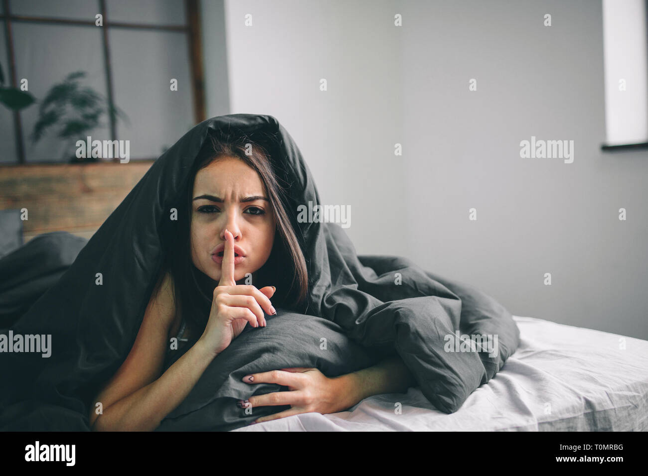Shocked young woman waking up with alarm. Girl overslept in bed and ...