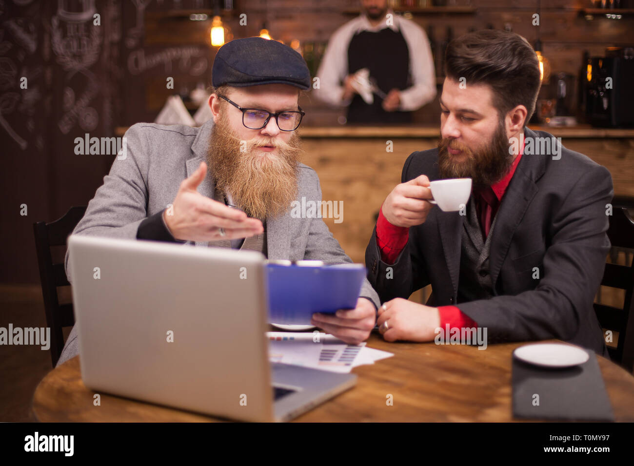 Bearded director drinking his coffee during a business meeting in a ...