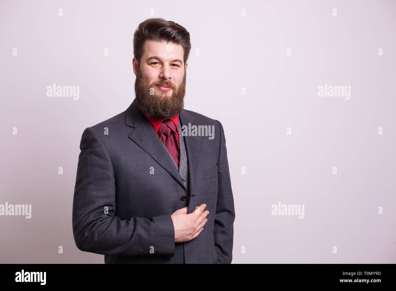 Smiling bearded man with suit jacket over white background. Confident ...