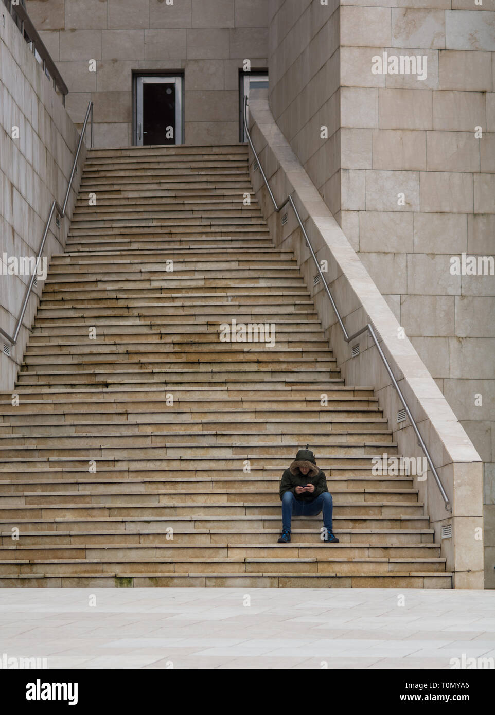 young man sitting on long flight of steps Stock Photo - Alamy