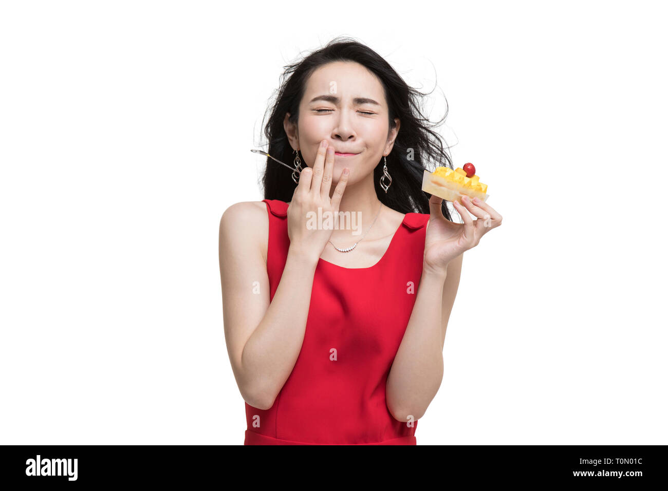 Happy young woman eating cake Stock Photo - Alamy