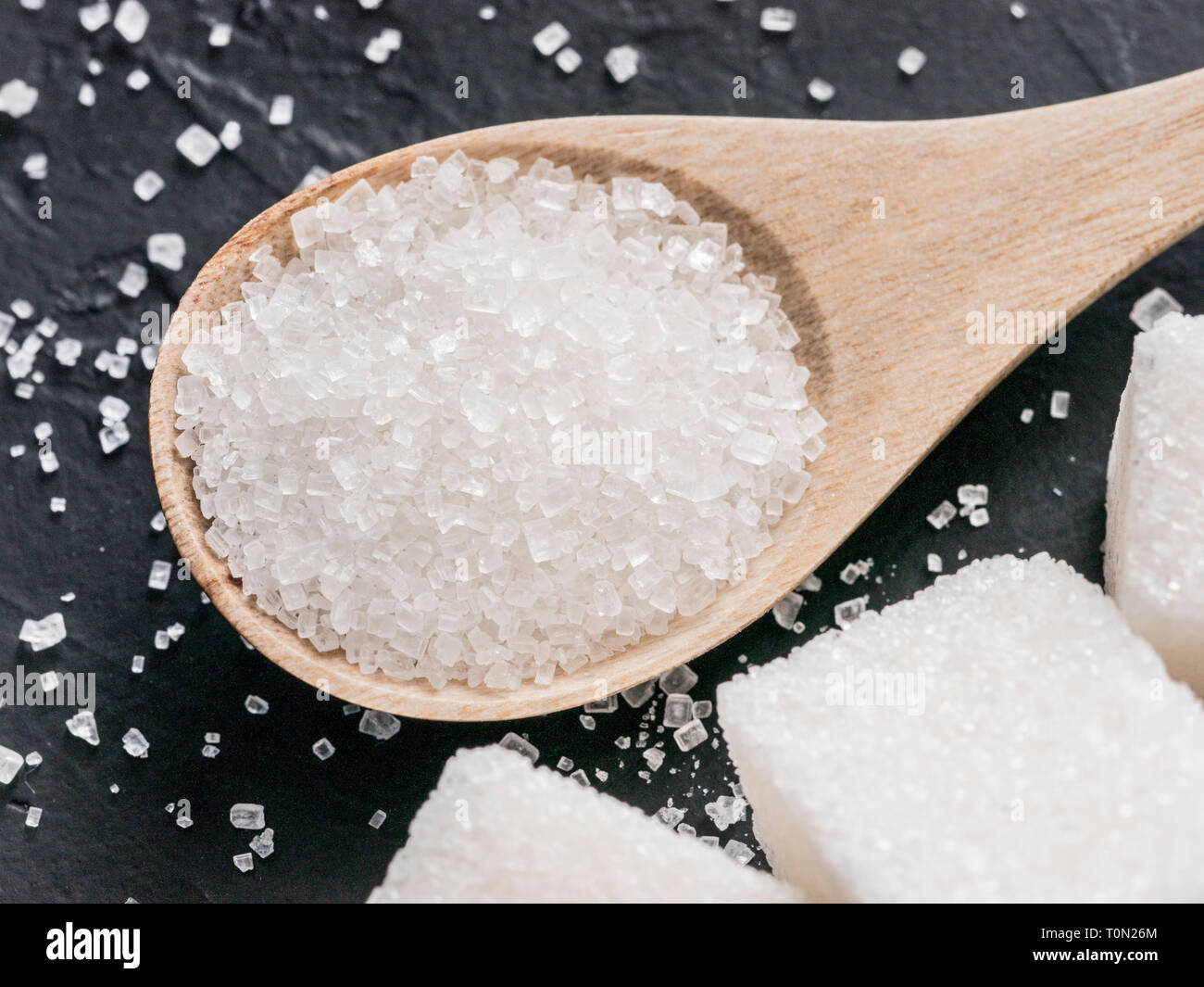 Granulated sugar in wooden spoon extreme close up. Background of sugar ...
