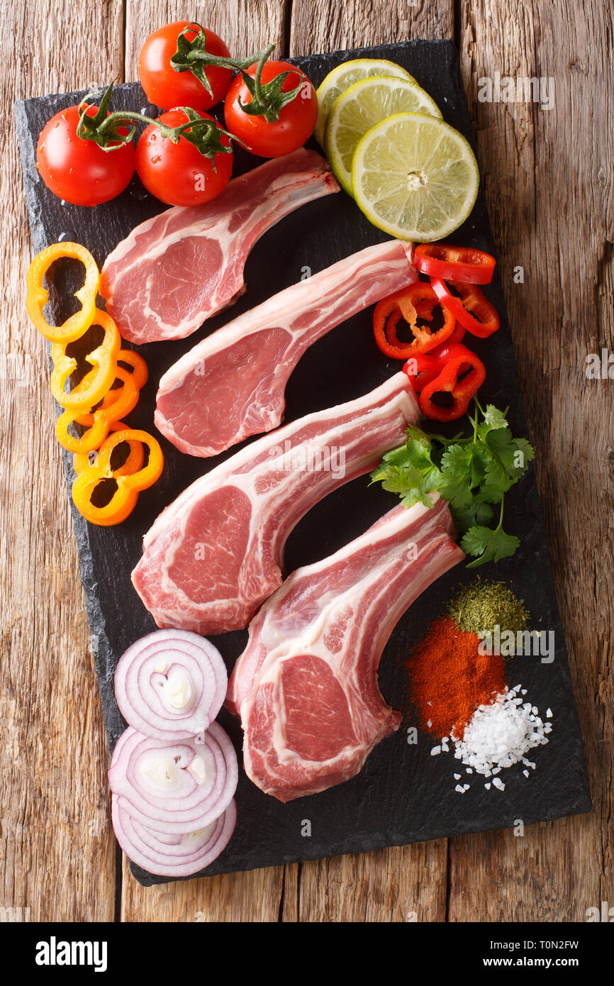Uncooked lamb chops with fresh vegetable ingredients and spices close ...