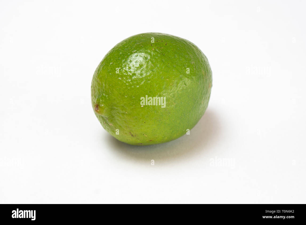 a lime on a plain white table Stock Photo - Alamy