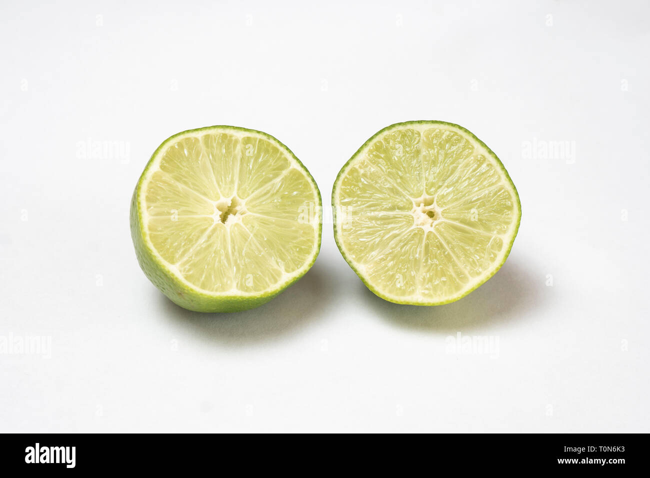 a cutted lime on a plain white table Stock Photo - Alamy