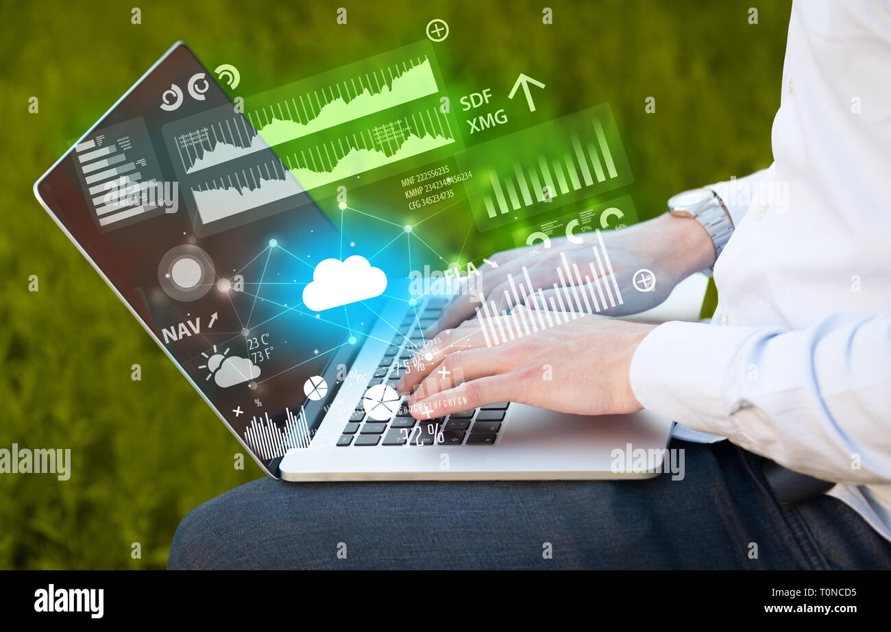 Hand using laptop with cloud technology and linked information concept ...