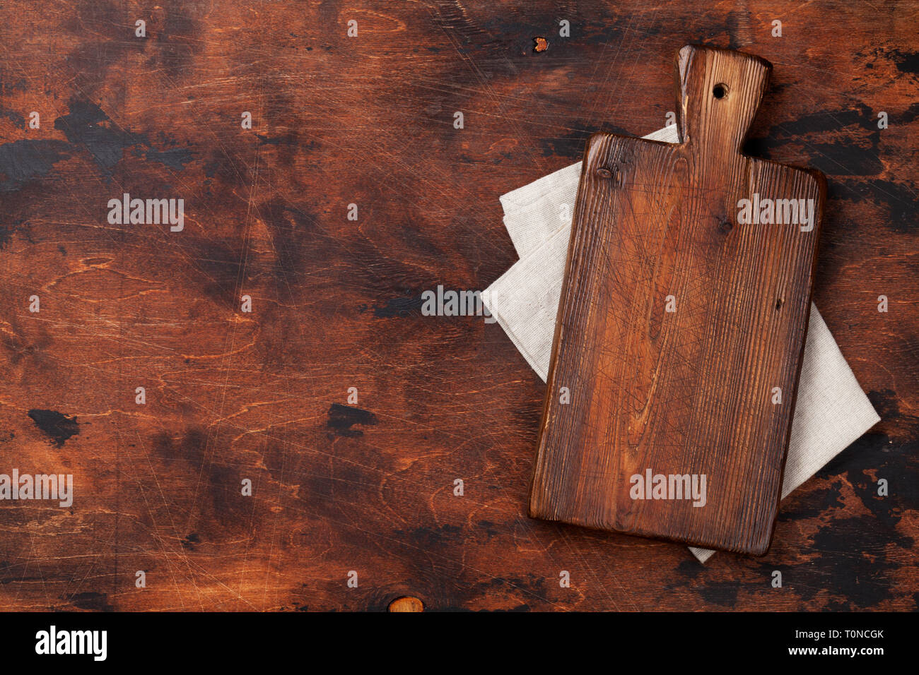 Cooking wooden table with cutting board over kitchen towel or napkin ...
