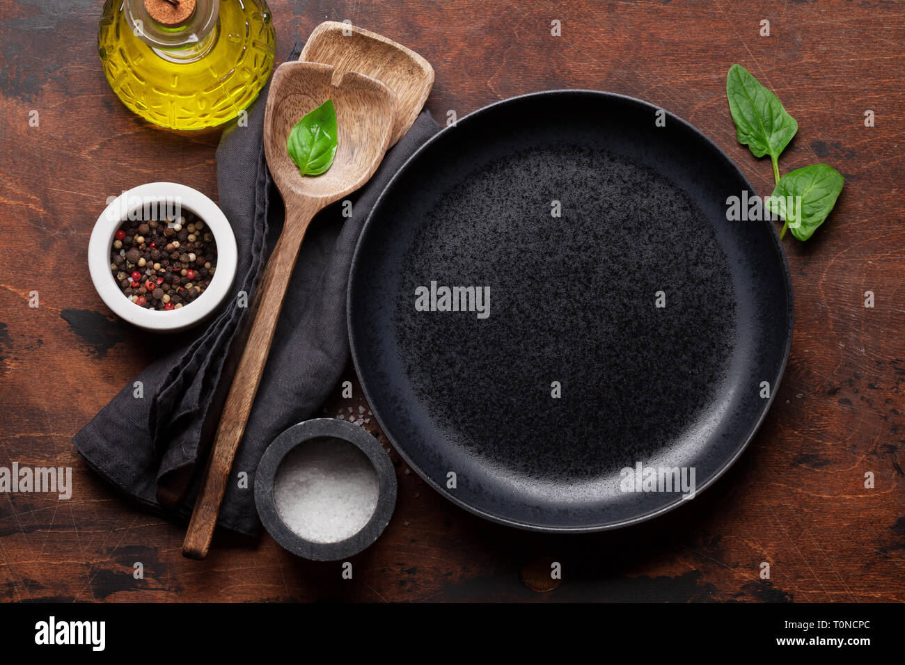 Cooking wooden utensils, empty plate, condiments and spices on wooden ...