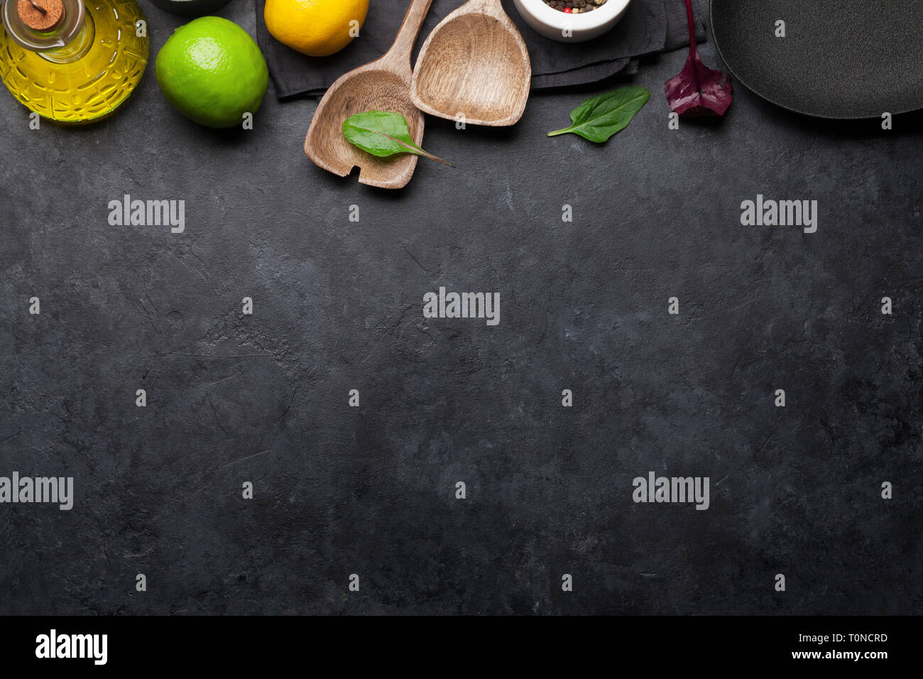 Cooking wooden utensils, empty plate, condiments and spices on stone ...