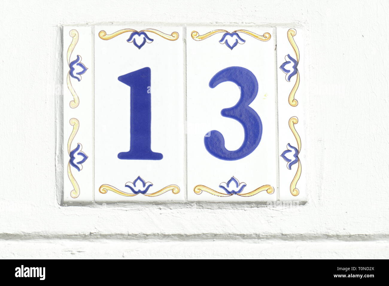 colorful house number plate number thirteen, colorful tile, white wall ...