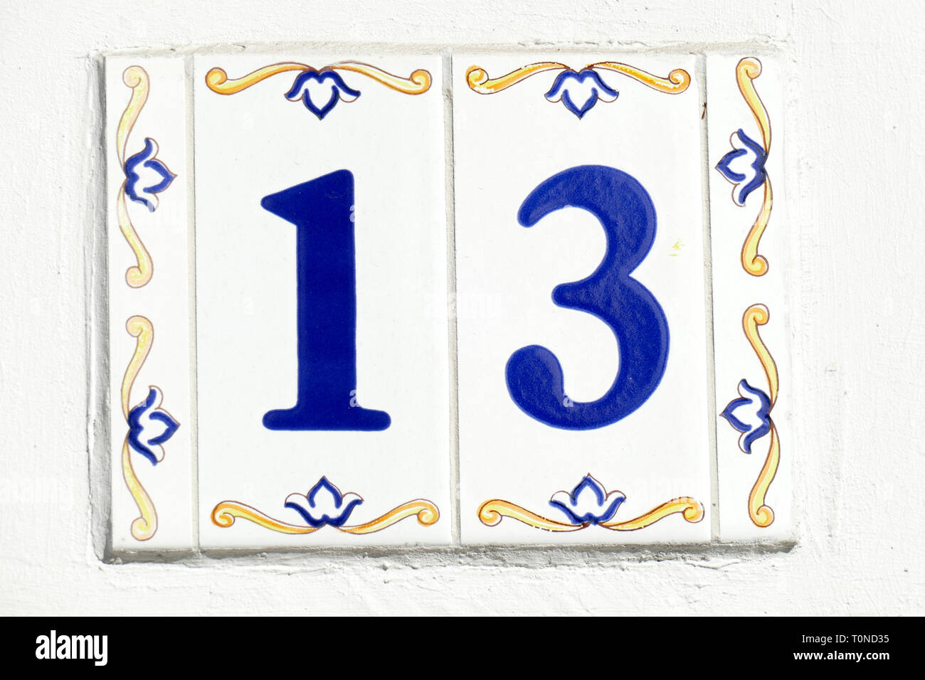 colorful house number plate number thirteen, colorful tile, white wall ...