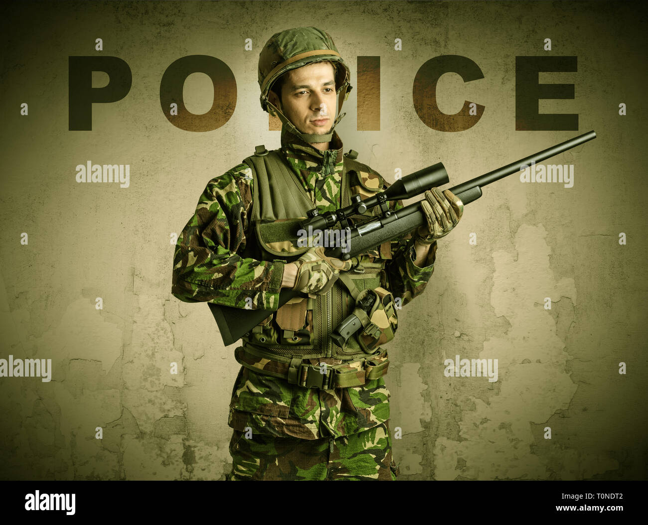 Uniformed armed soldier with damaged wall background Stock Photo - Alamy