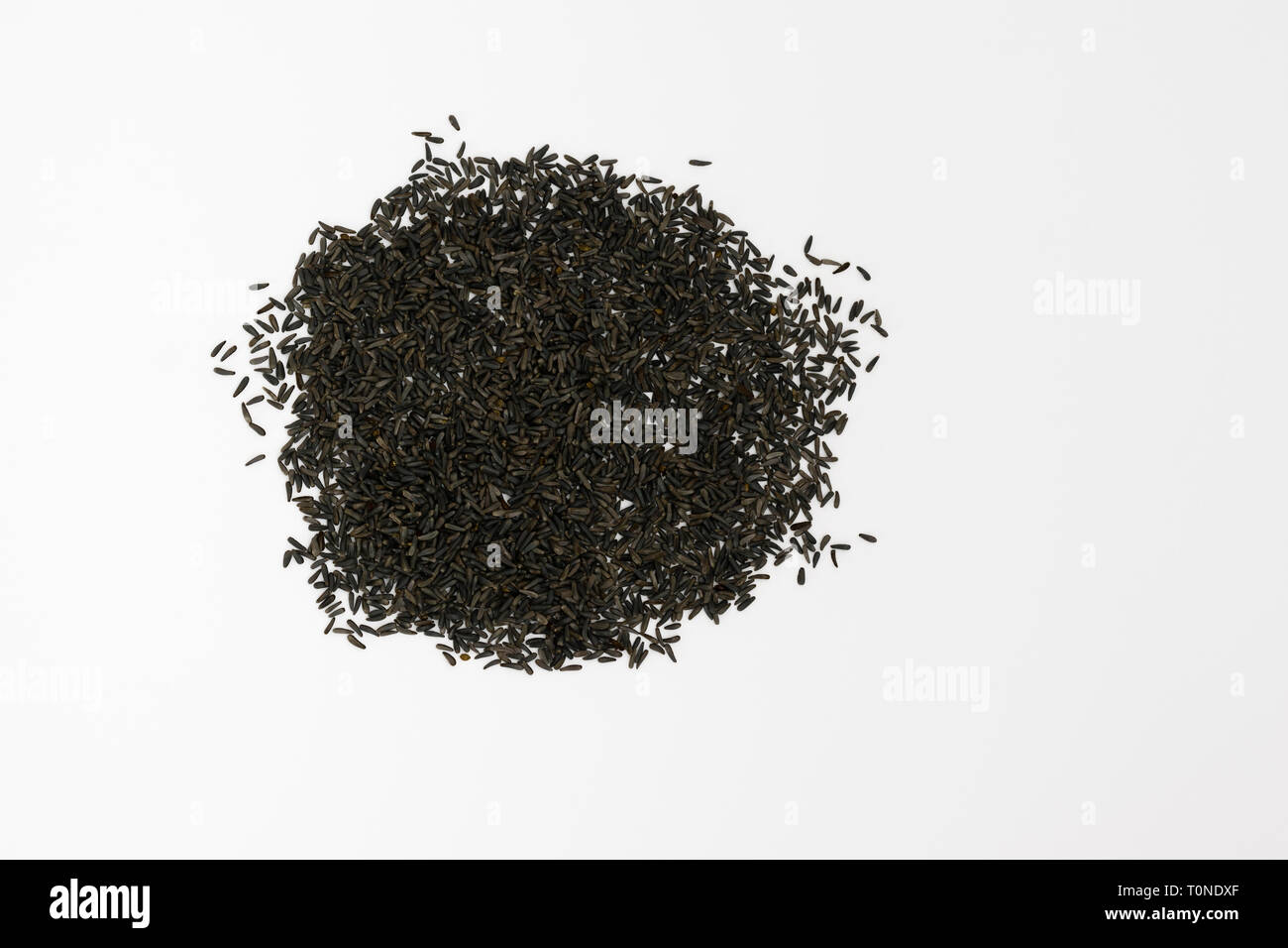 Blackseeds or Niger seeds (Guizotia abyssinica) on a white background ...