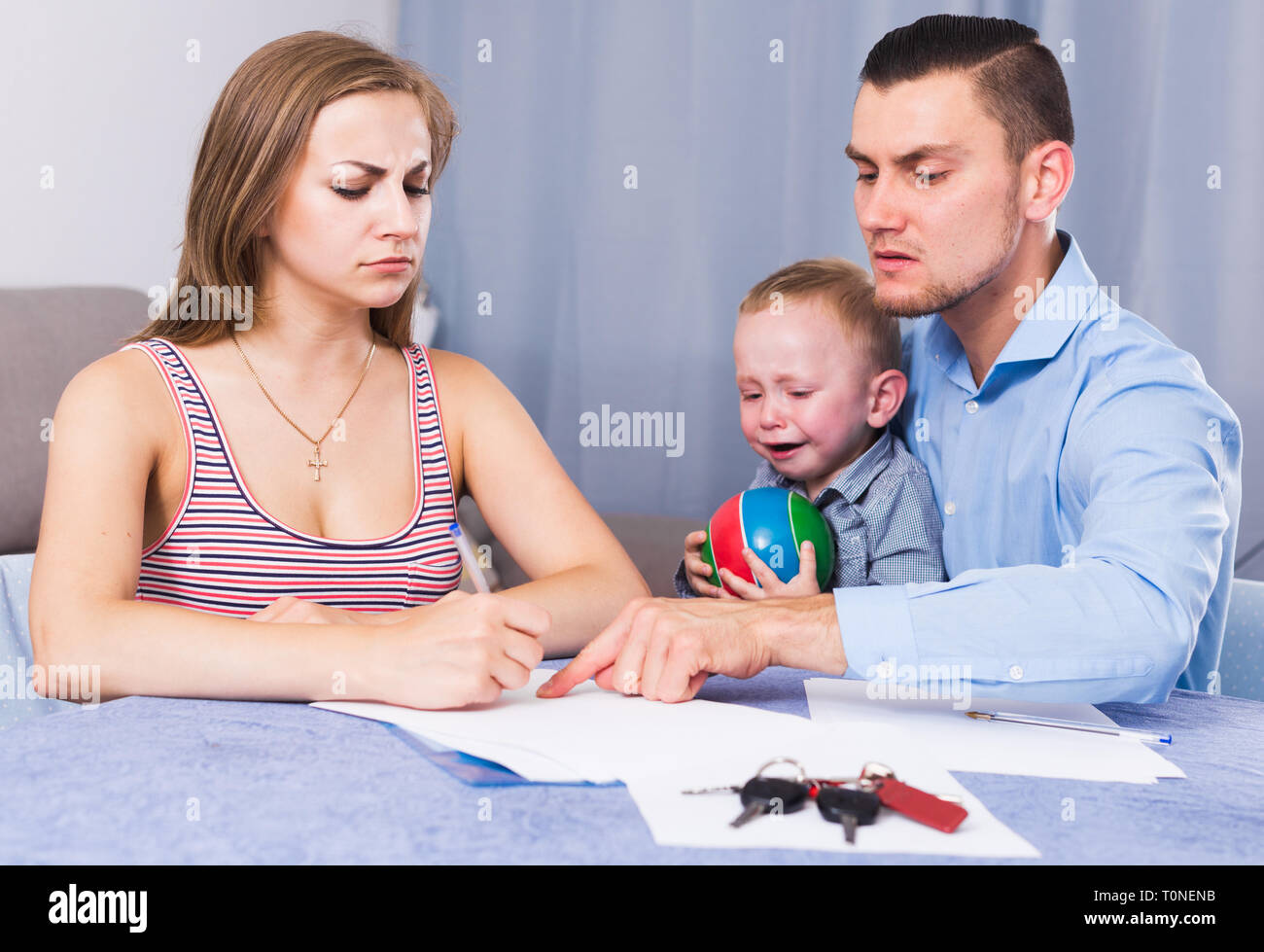 Sad woman with crying boy signing documents about share of property ...
