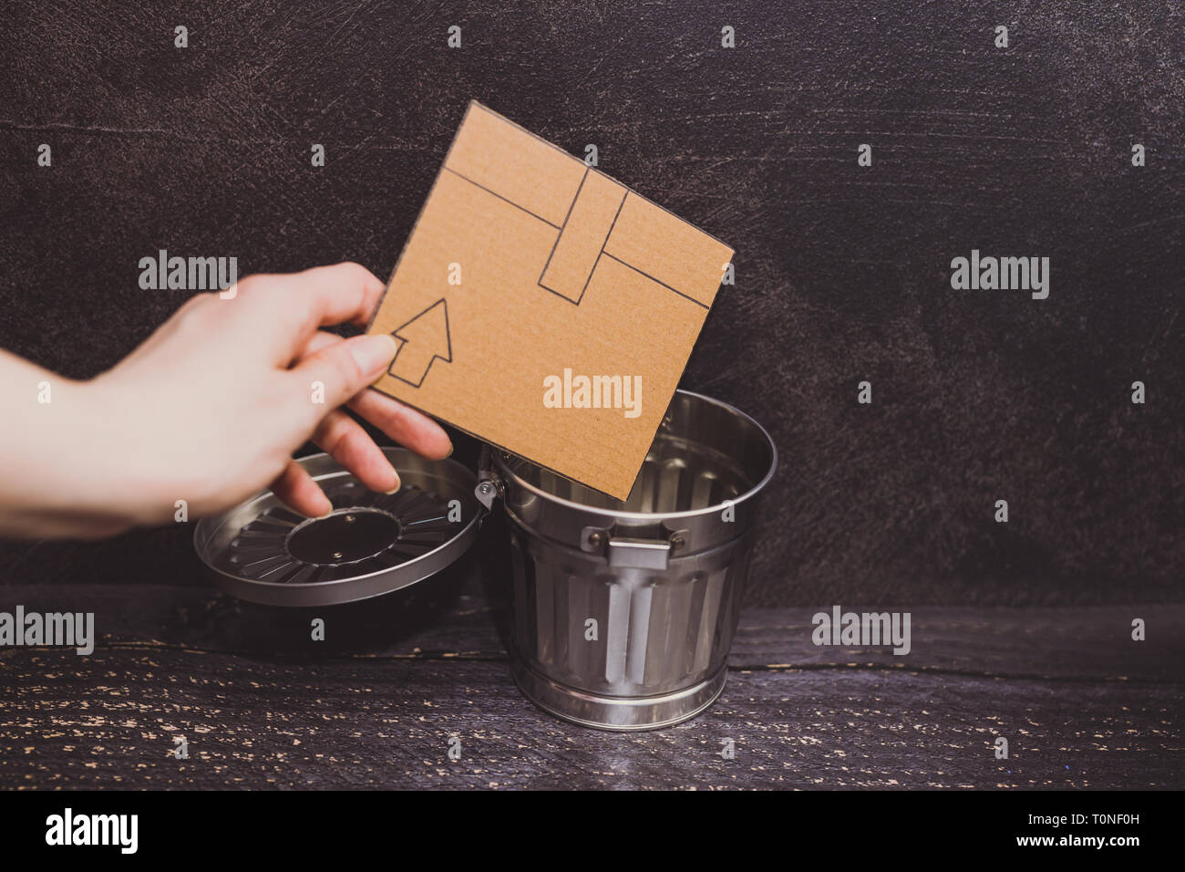 mini cardboard box going into a garbage bin, concept of recycling or ...