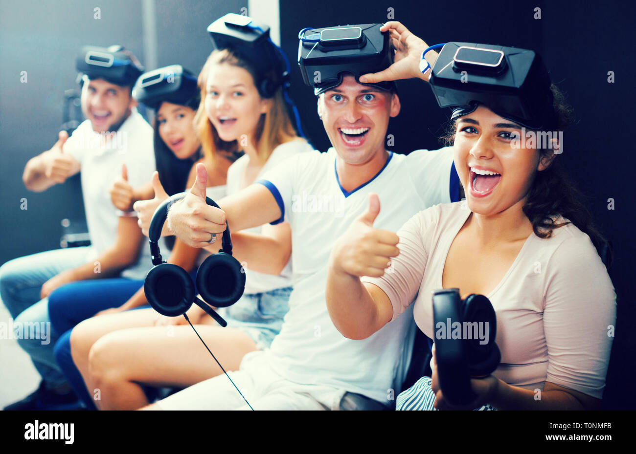 Happy young people expressing satisfaction with vr attraction showing ...