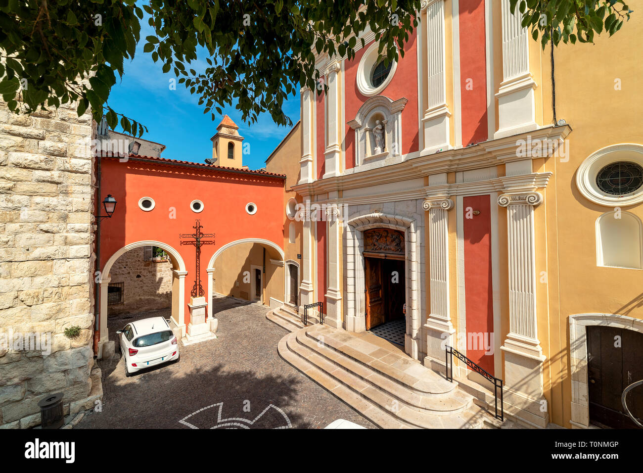 View of Antibes Cathedral on small town square and arched passage in ...