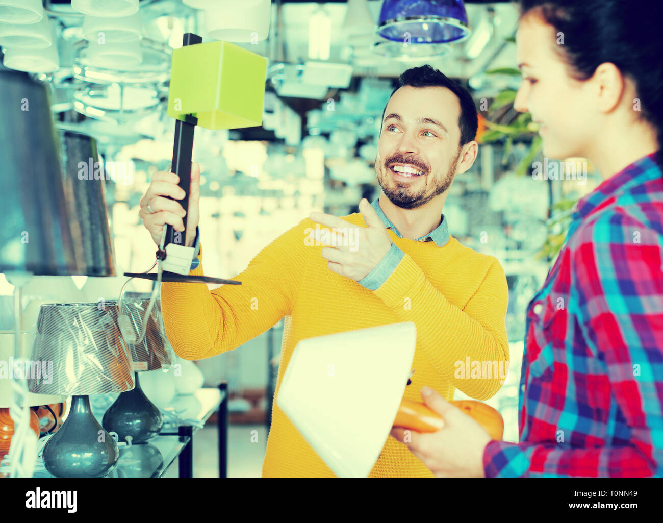 Adult man and girl in lighter shop choose table lamp for house Stock ...