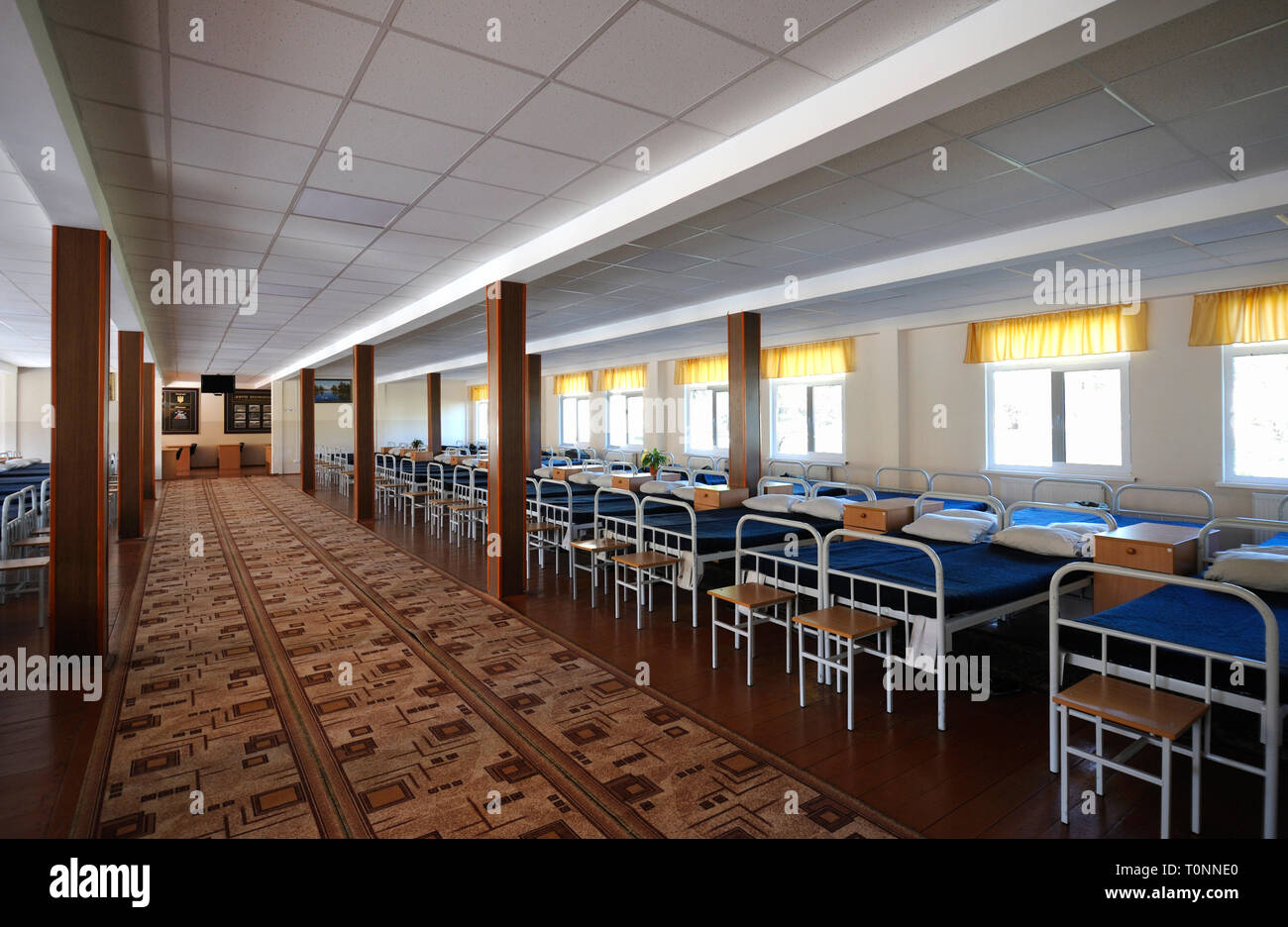 Room of barrack for soldiers with well-made beds, nightstands, benches ...