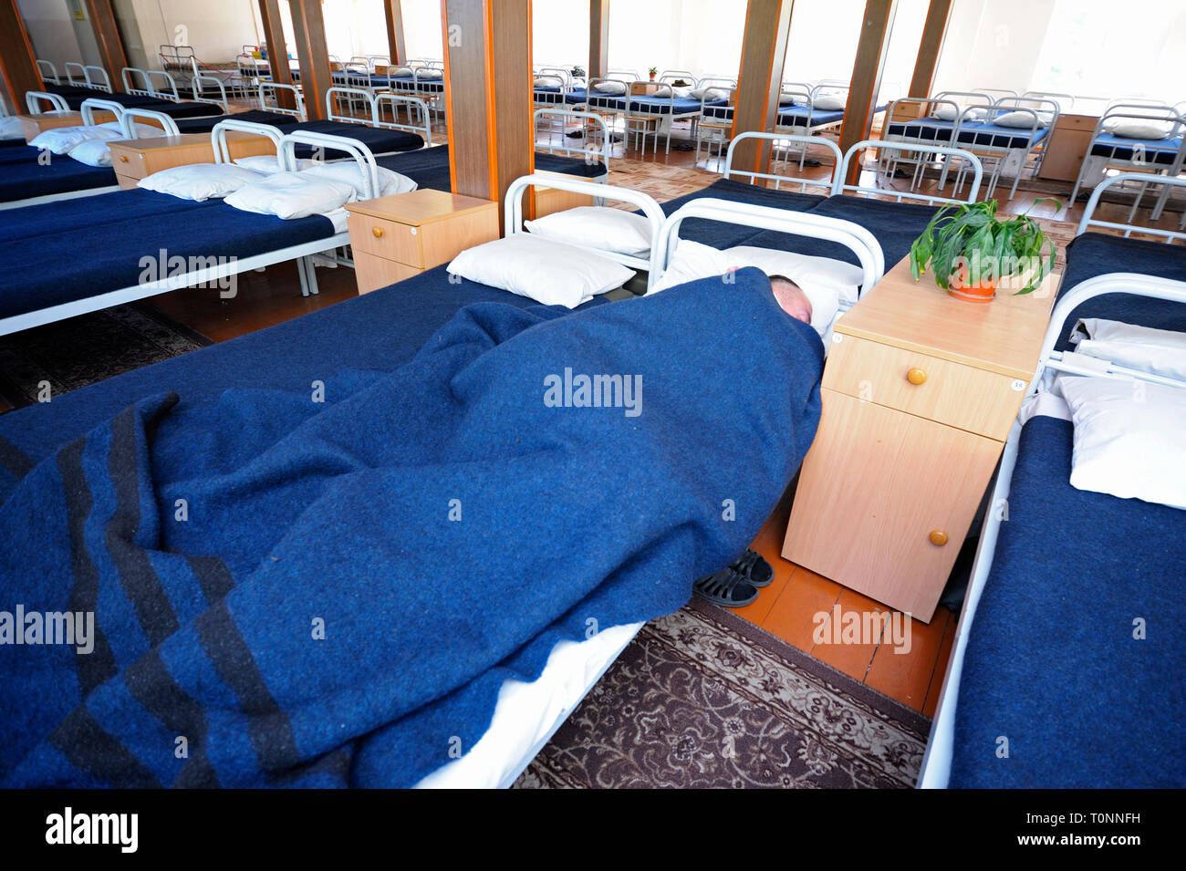 Room of barrack for soldiers: soldier sleeps in bed, well-made beds ...