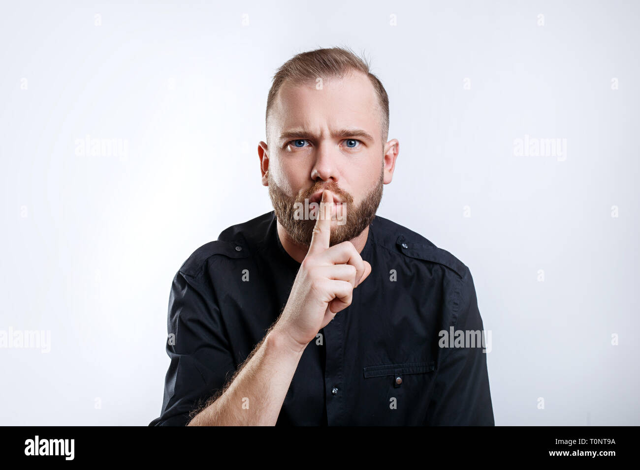 Serious male with silence hand gesture hi-res stock photography and ...