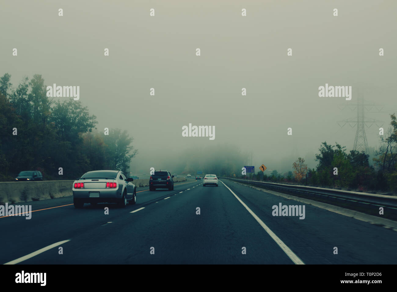 Traffic on highway in fog mist. Cars on freeway road at evening in ...