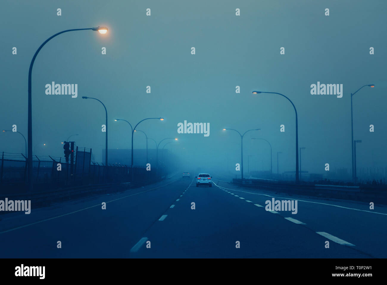 Highway in mystic fog mist smog. Cars on freeway road at evening in ...