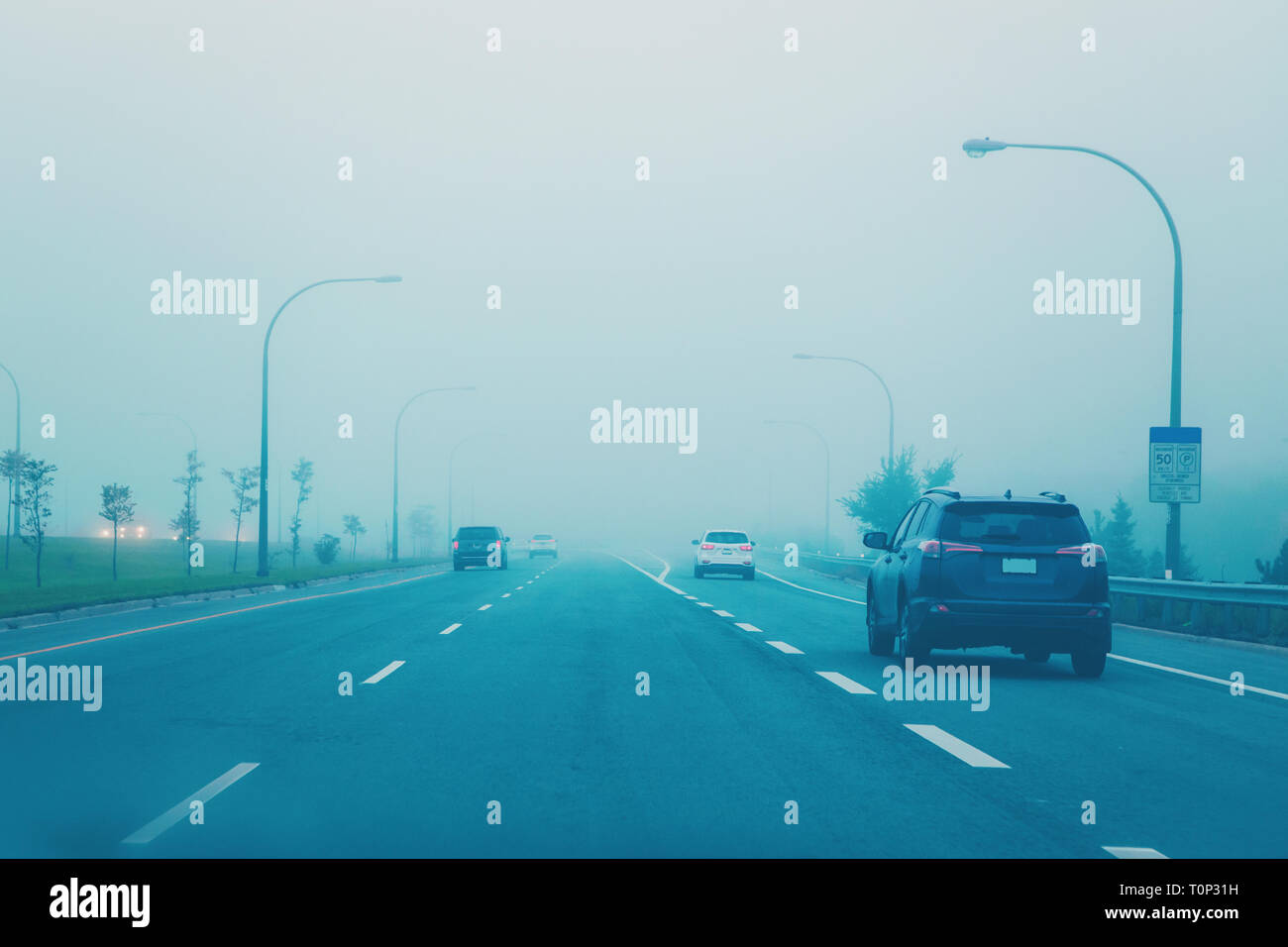 Highway in mystic fog mist smog. Cars on freeway road at evening in ...
