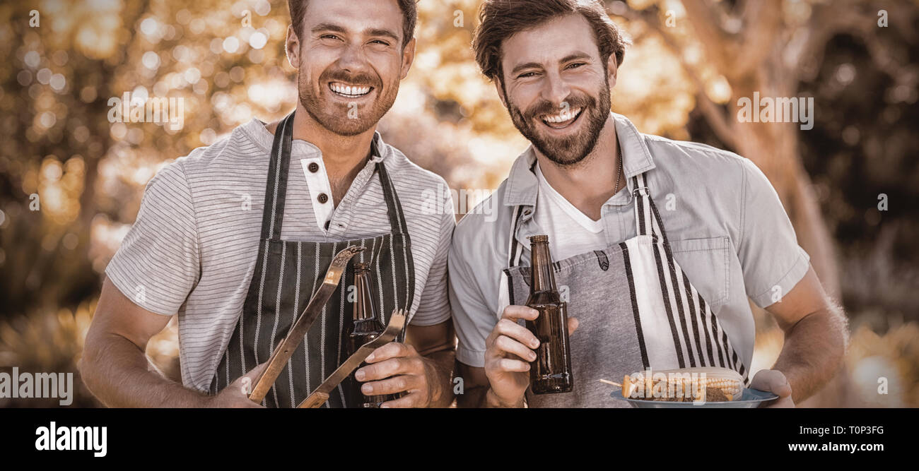 Portrait of two happy men holding barbecue meal and beer bottle Stock ...