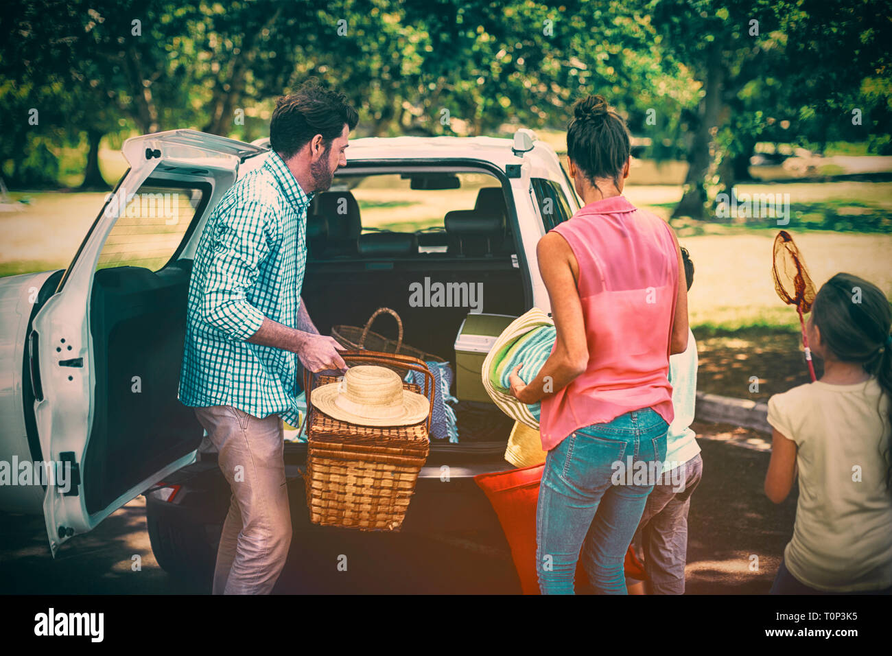 Family placing picnic items in car trunk Stock Photo - Alamy