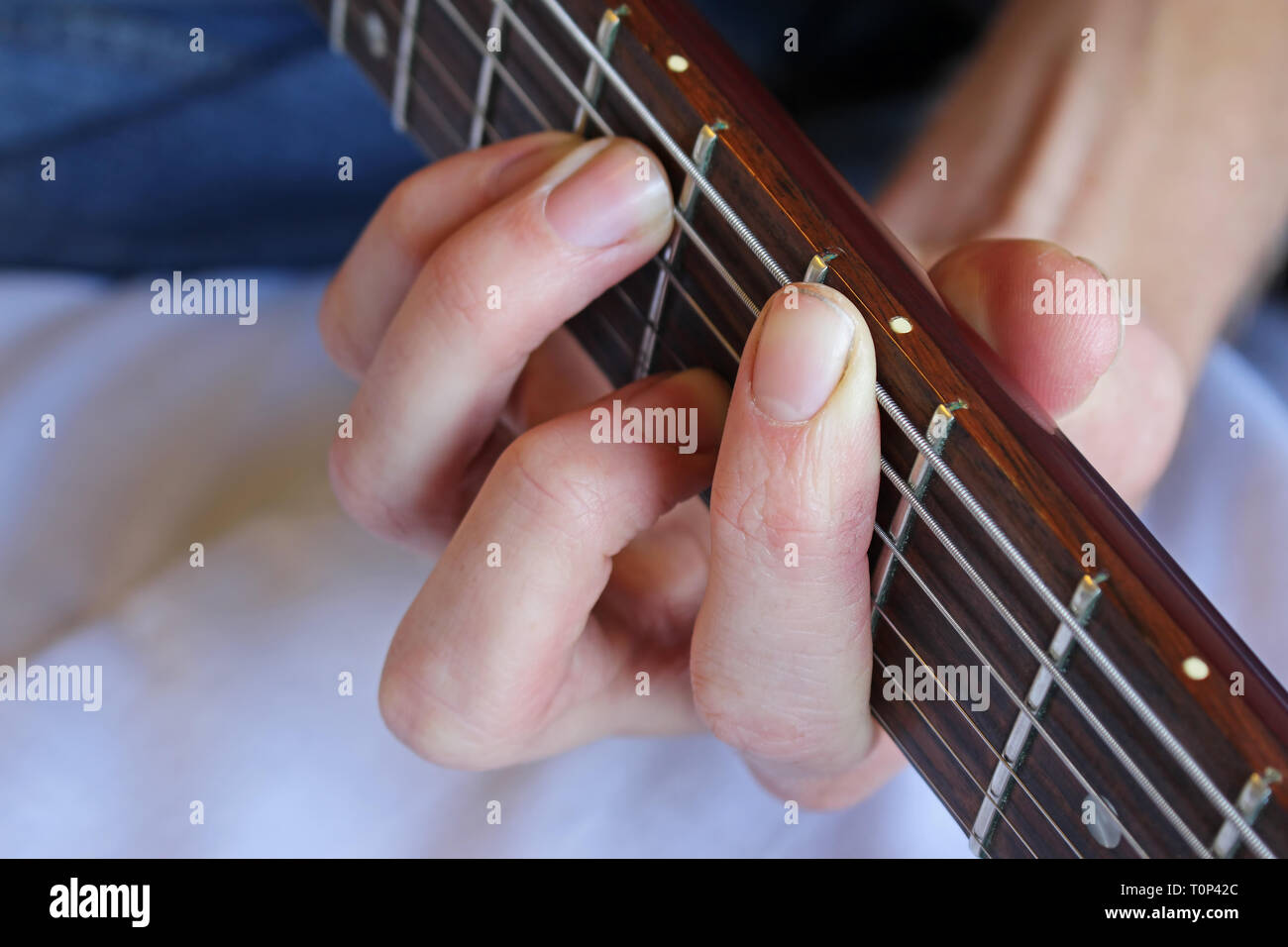 Guitar player's hand forming a chord on the fretboard of a guitar Stock ...
