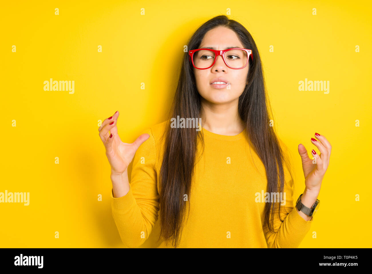 Beautiful brunette woman wearing red glasses over yellow isolated ...