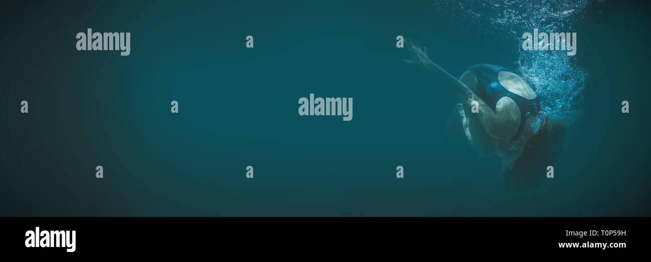 Athletic swimmer doing a somersault underwater Stock Photo - Alamy