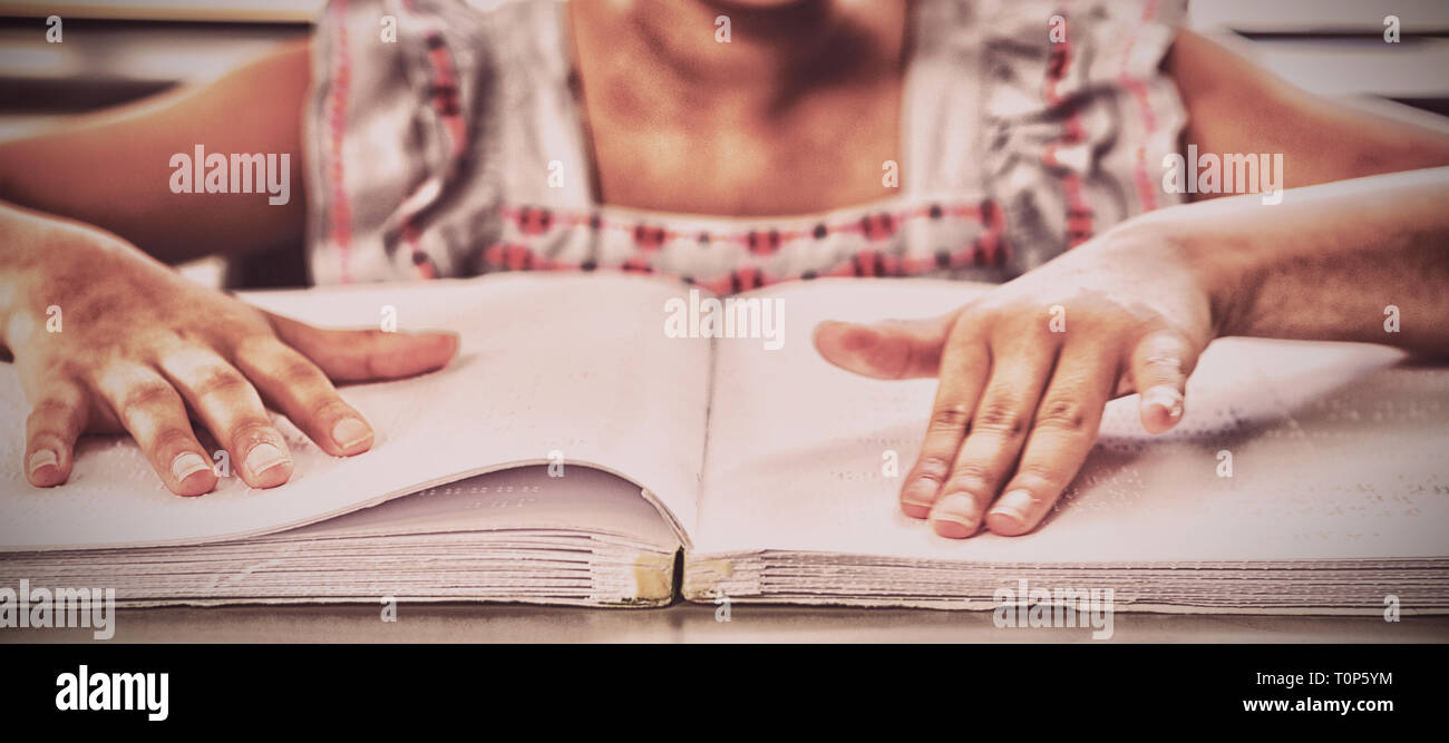 Midsection of blind girl reading braille book Stock Photo - Alamy