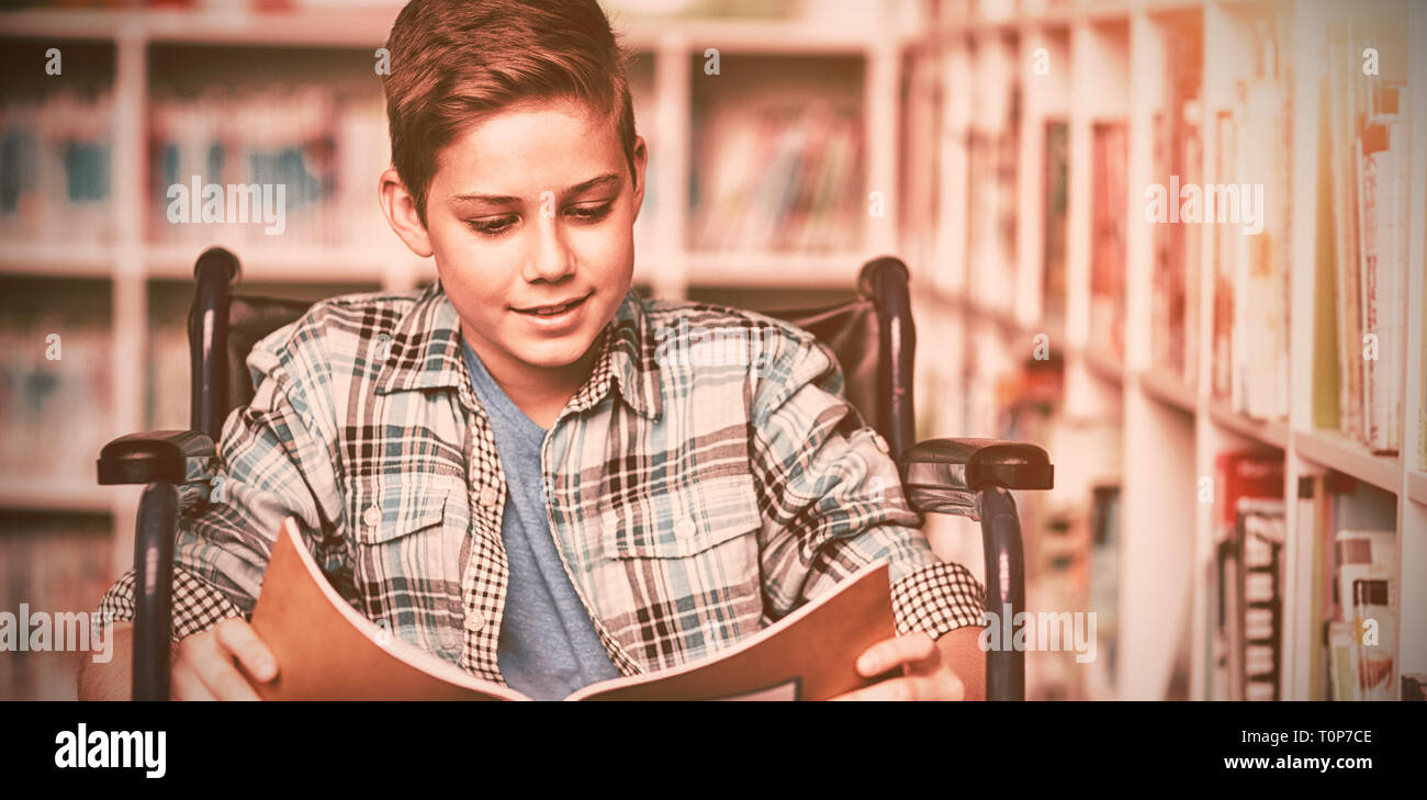 Disabled schoolboy reading book in library Stock Photo - Alamy