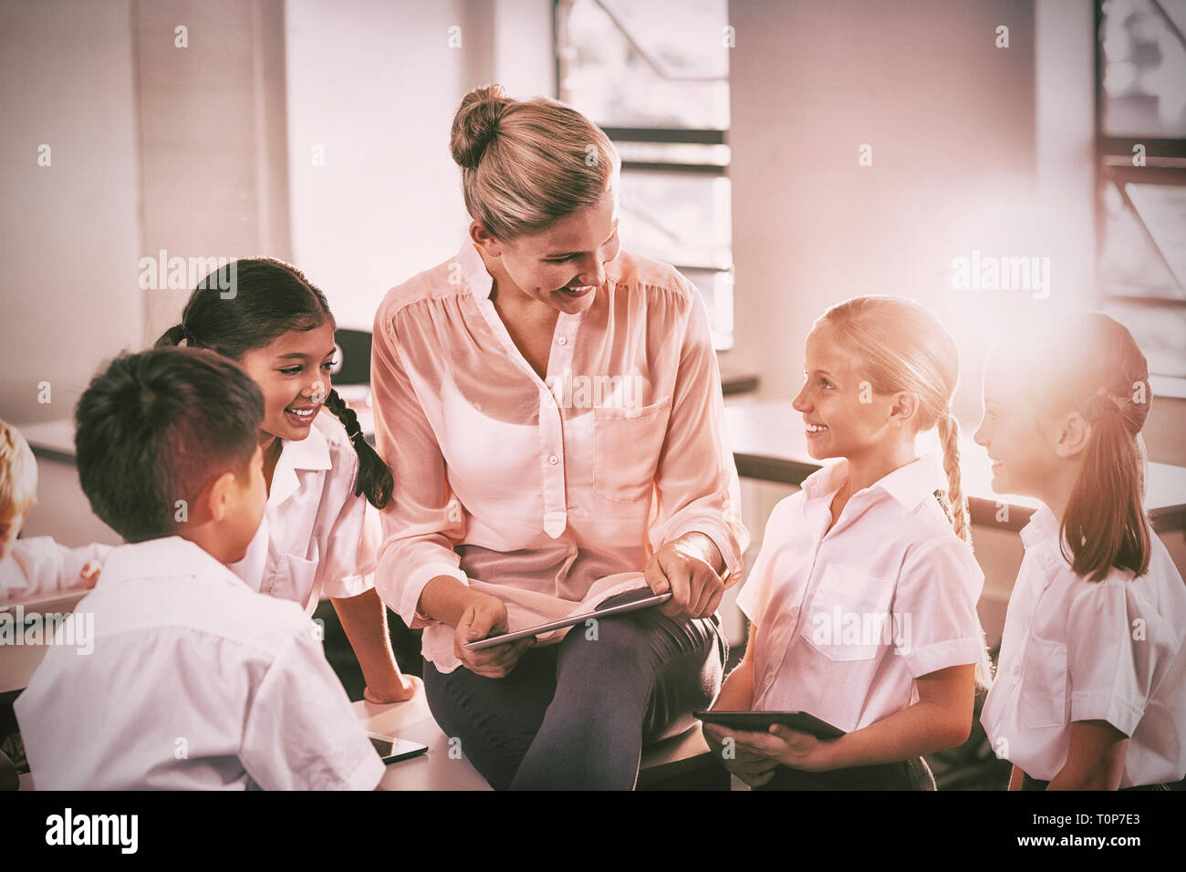 Teacher with digital tablet teaching children Stock Photo - Alamy
