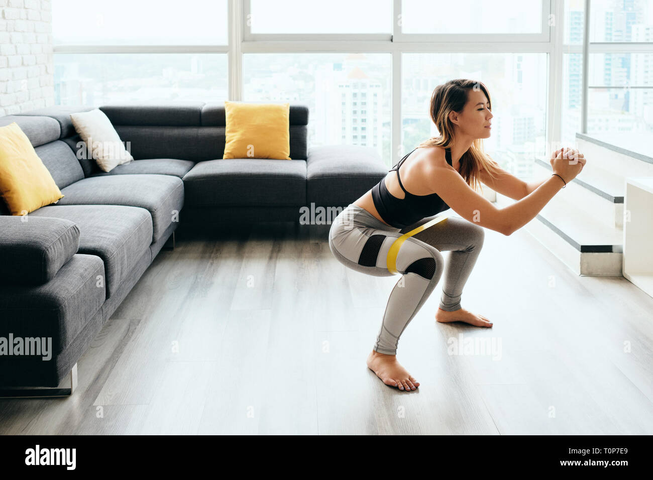 Adult Woman Training Legs Doing Side Squat at Home Stock Photo - Alamy