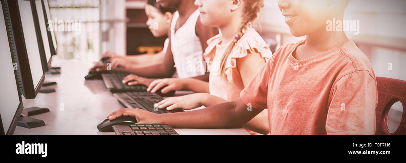 School kids using computer in classroom Stock Photo - Alamy