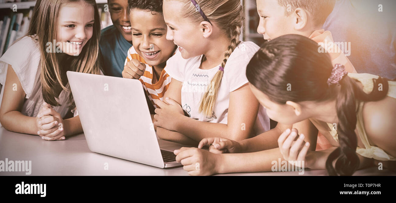 School kids using laptop in library Stock Photo - Alamy