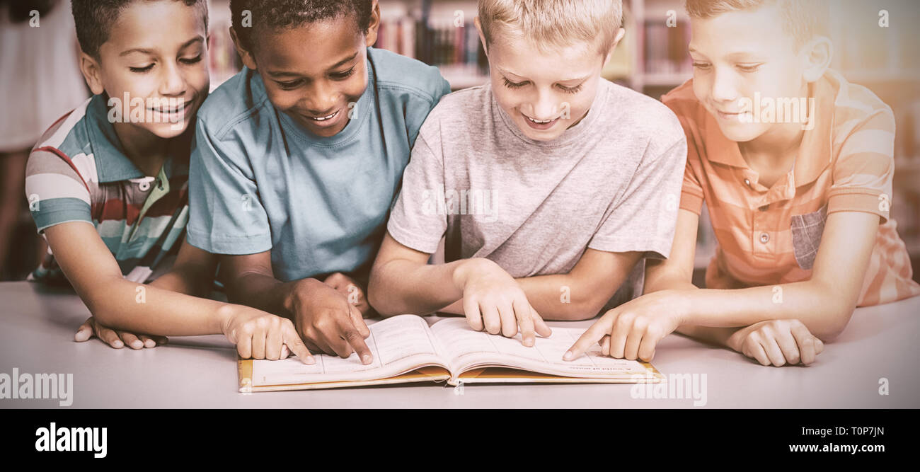 School kids reading book together in library Stock Photo - Alamy