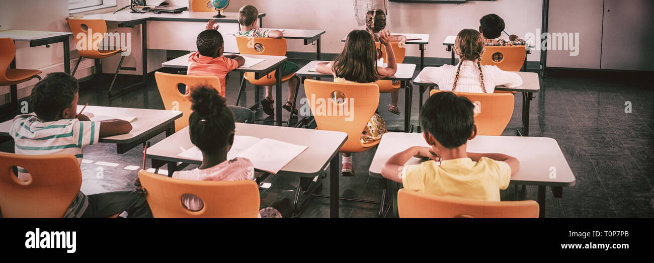 Teacher giving lesson to her students Stock Photo - Alamy